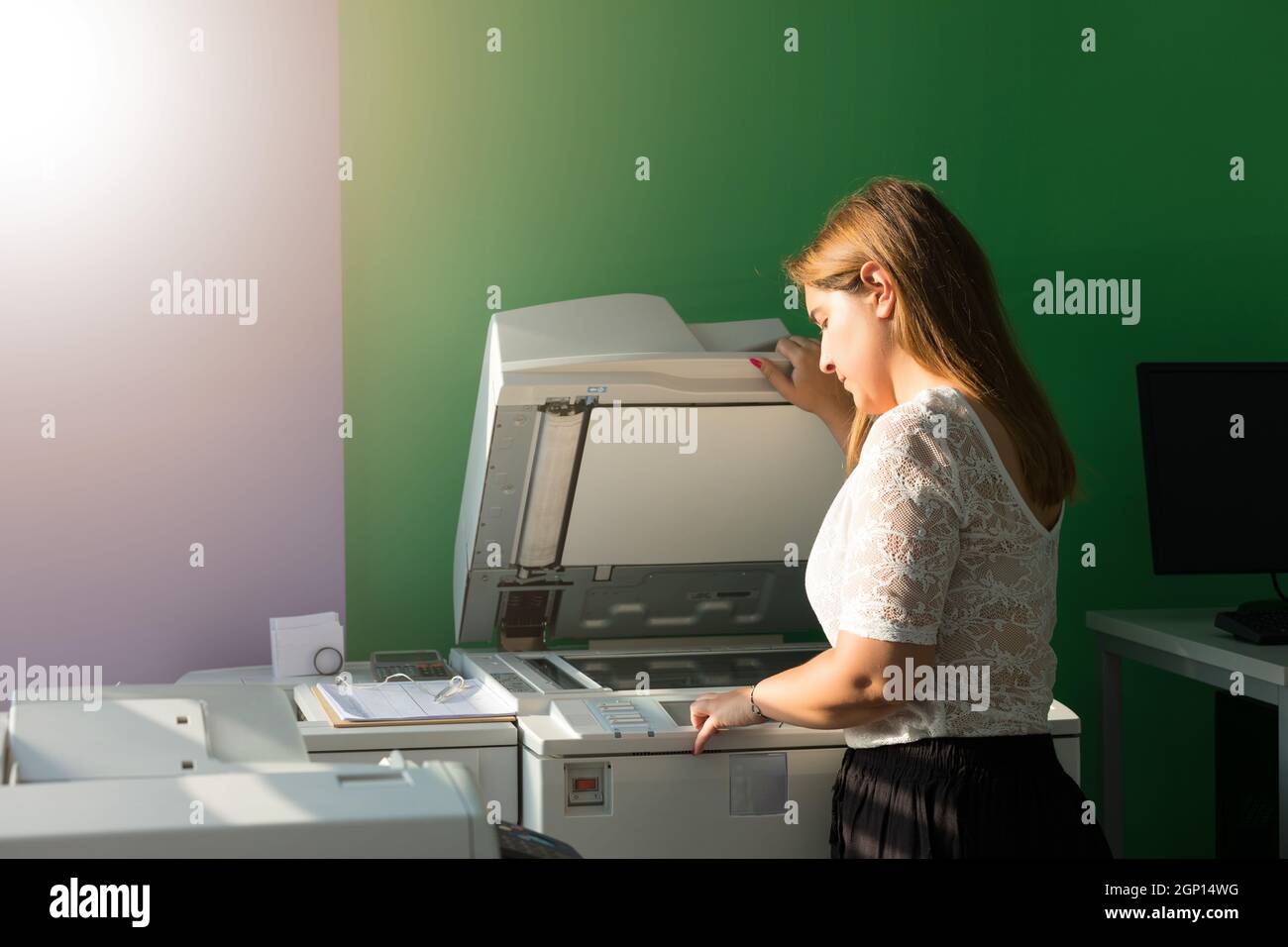 A young student at a copy center taking some copies for her final exams ...