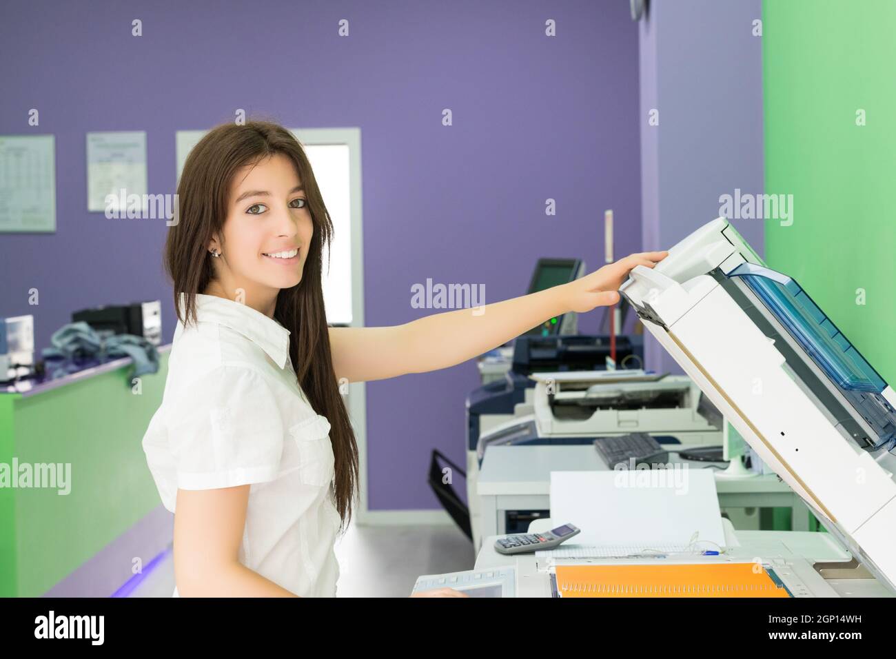 A young student at a copy center taking some copies for her final exams ...