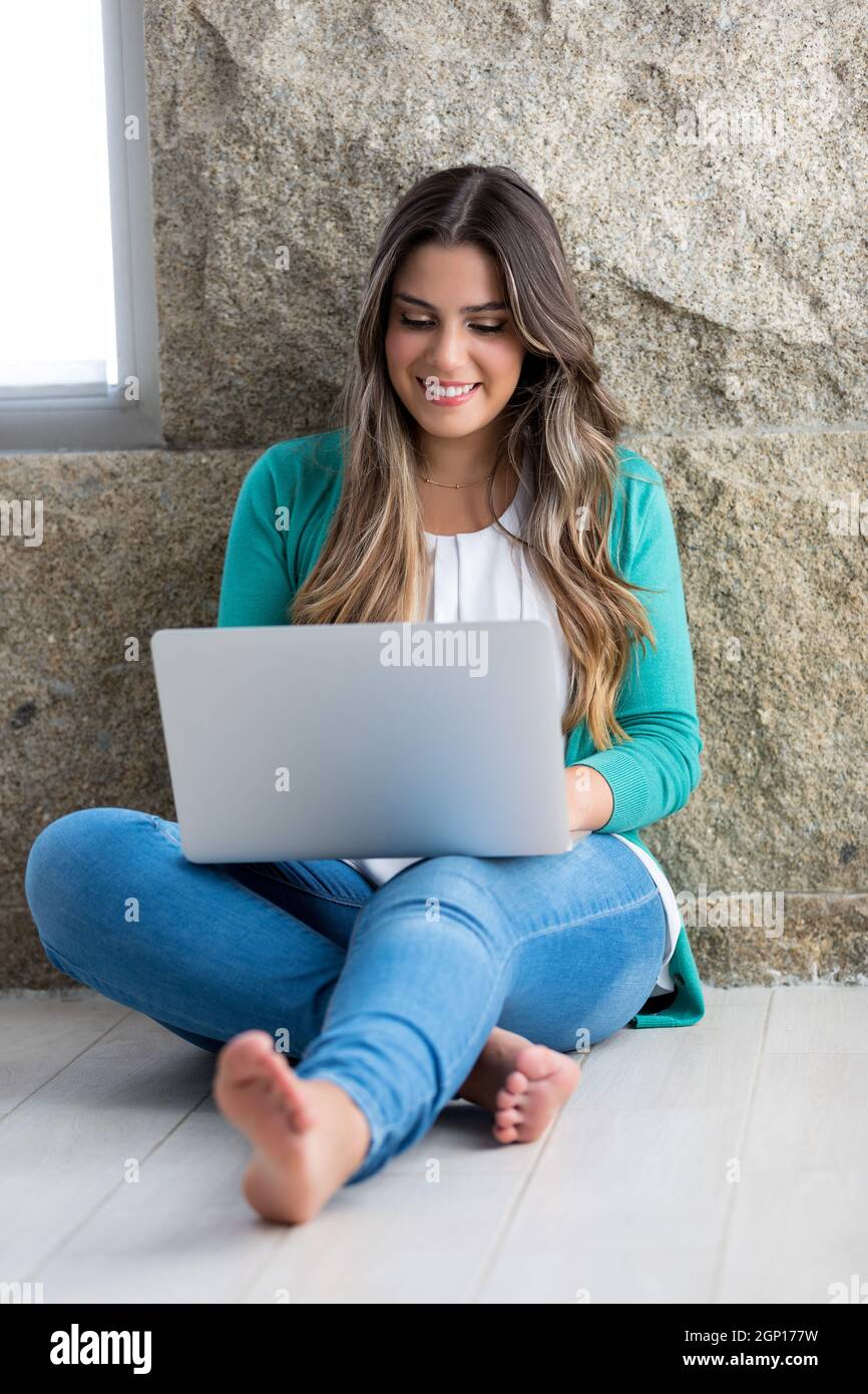 Beautiful young woman relaxing at home on her laptop computer Stock ...
