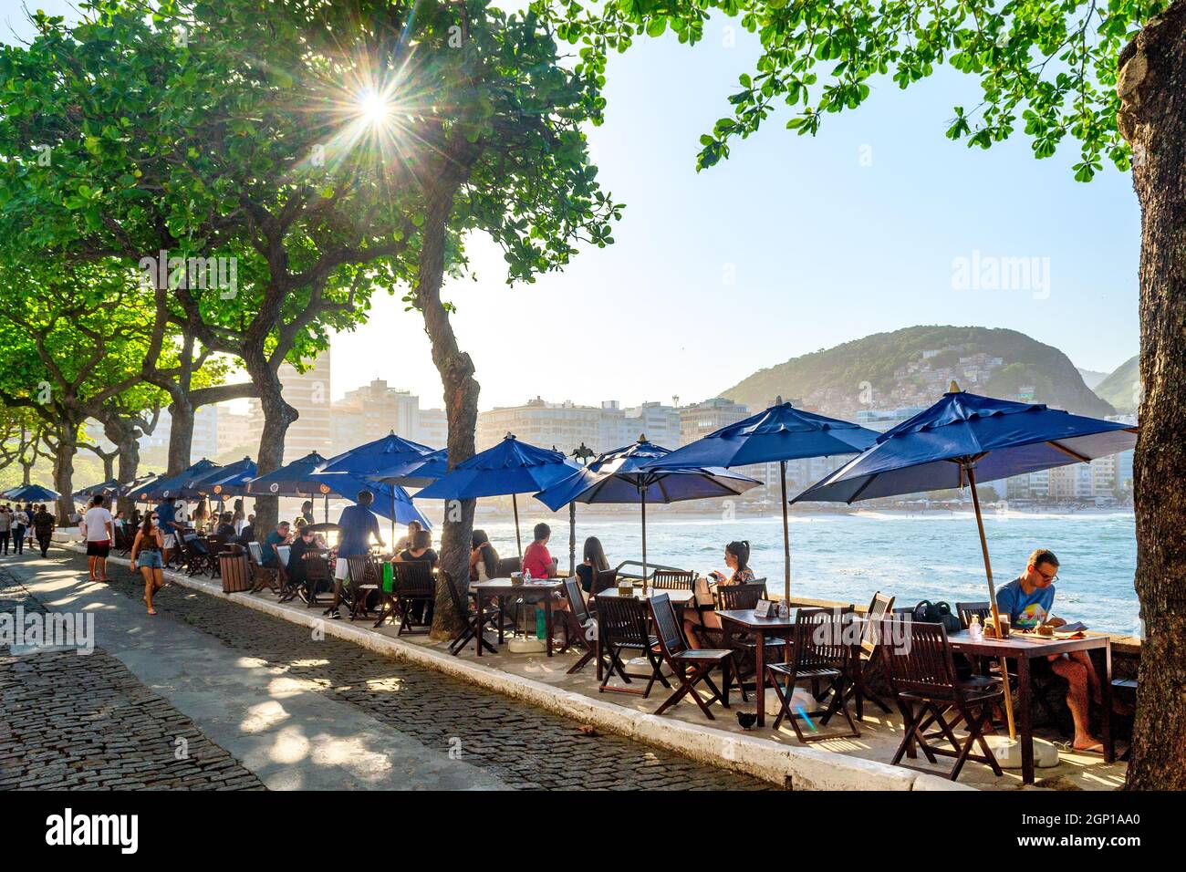 Tourists sitting in restaurant patio business by the Copacabana Beach ...