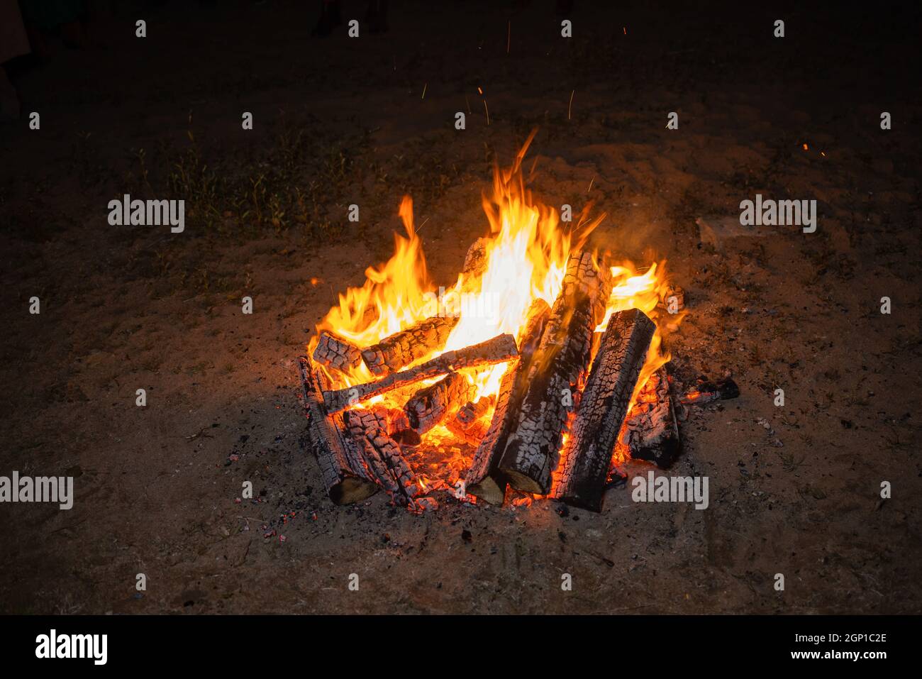 Photo of a night bonfire against a dark background. Flames scatter ...