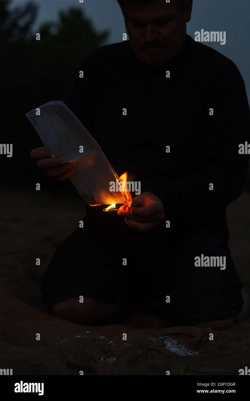 An adult male holds on to the burning documents. Sheets tore out Stock ...