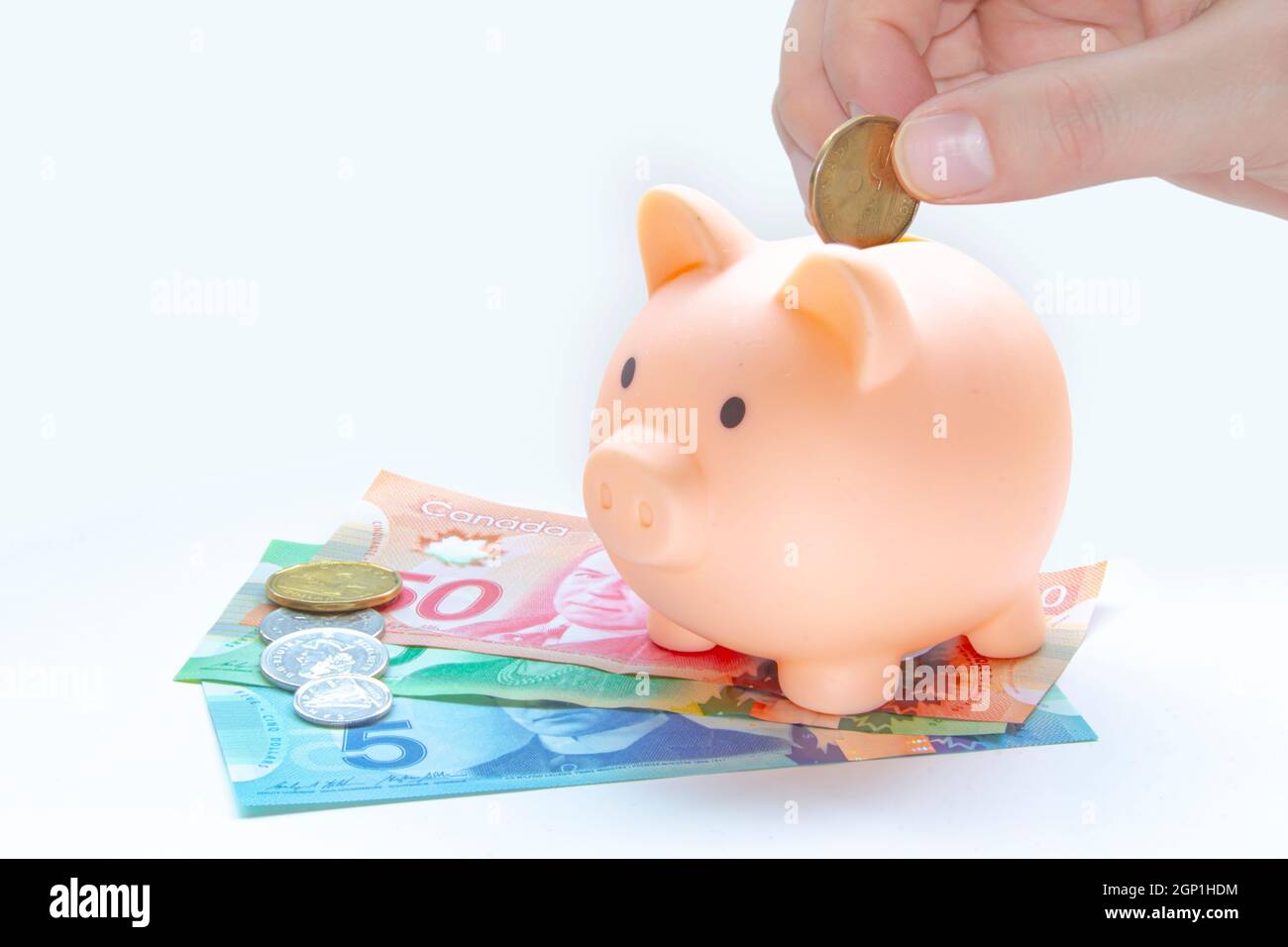 Calgary, Alberta, Canada. Dec 7 2020. A person saving Canadian currency ...