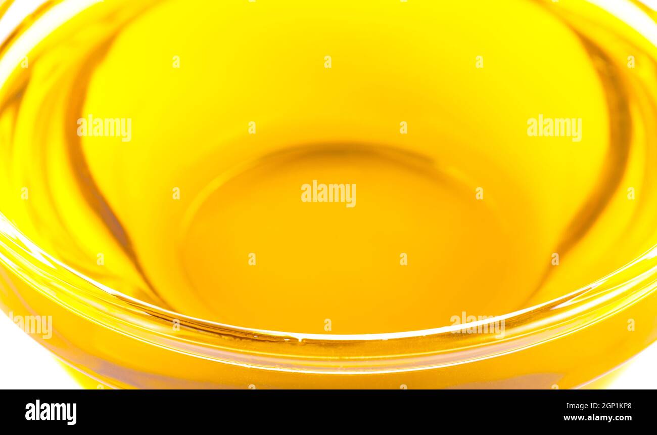 Pouring cooking oil a small glass cup isolated on white background ...