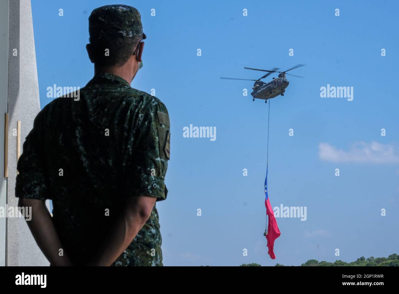 Military personnel watches a military helicopter (Boeing CH-47 Chinook ...