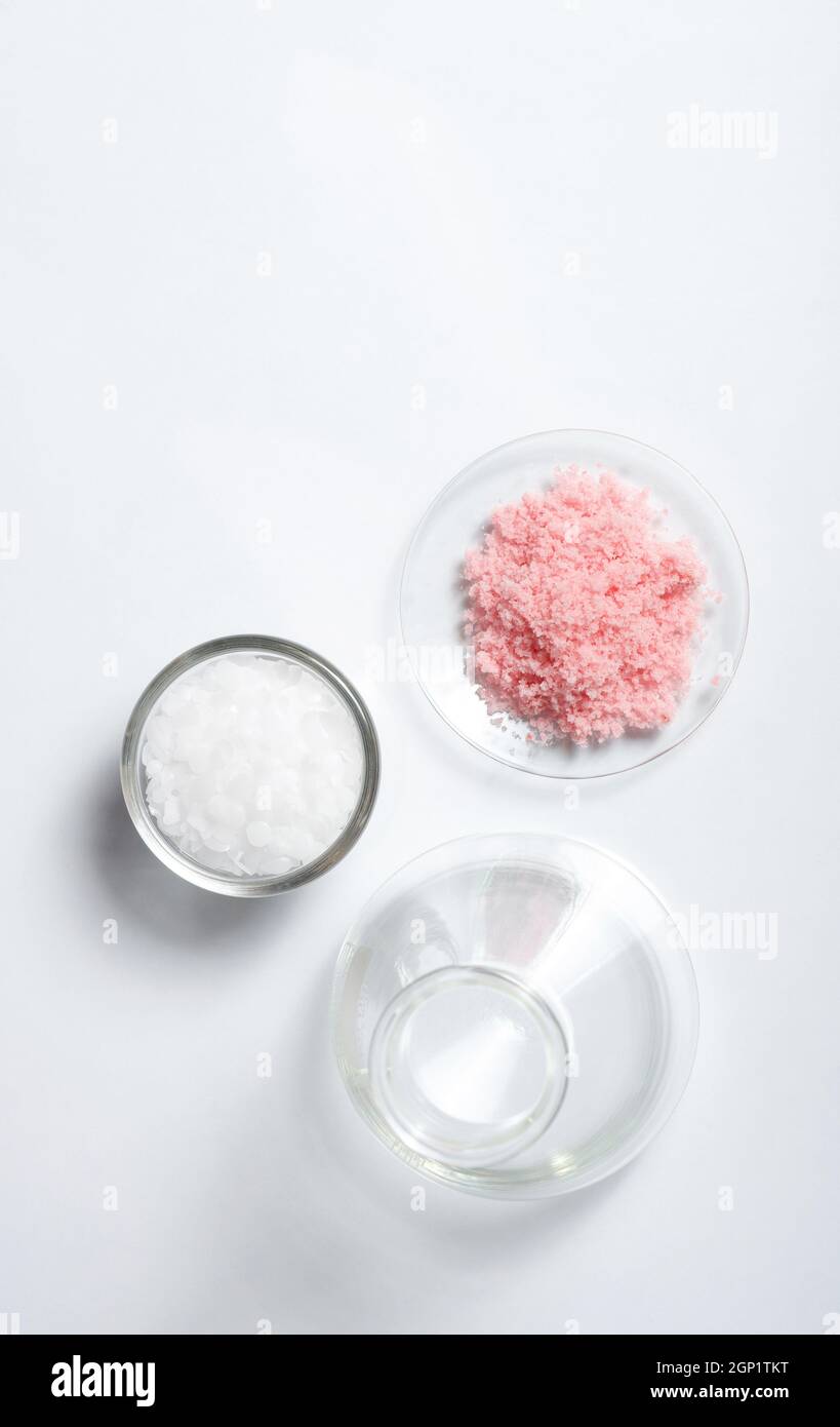 Chemicals for beauty care on white laboratory table. Pink flake ...