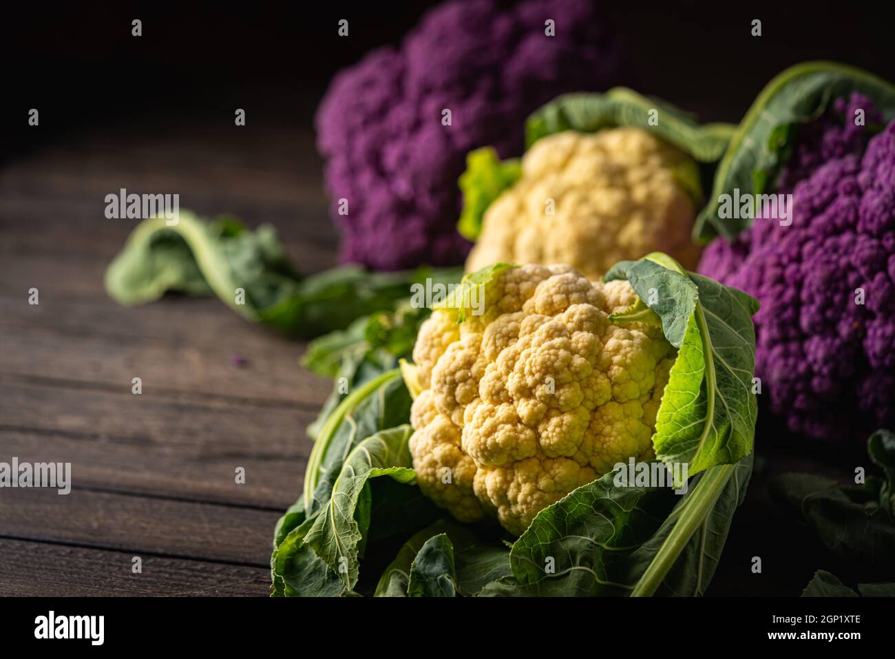 Raw fresh colorful cauliflowers on a dark wooden background. Healthy ...