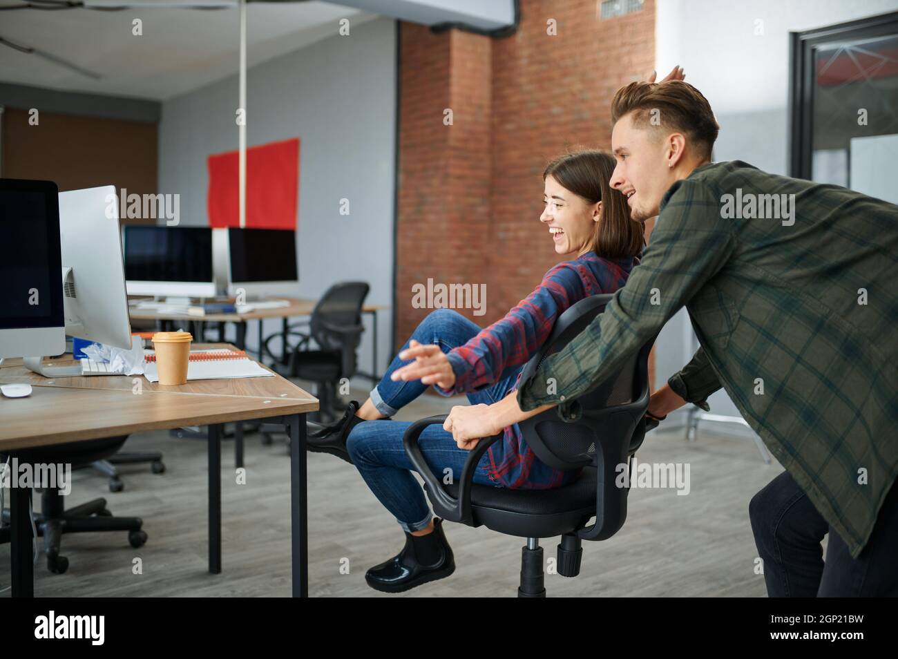 Cheerful IT specialists looks on monitor in office. Web programmer or ...