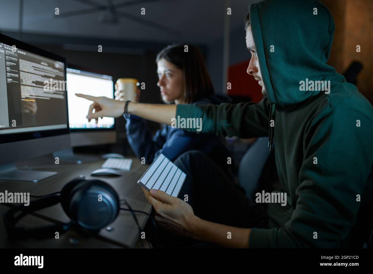 Male and female hackers works on computers in darknet, dangerous ...