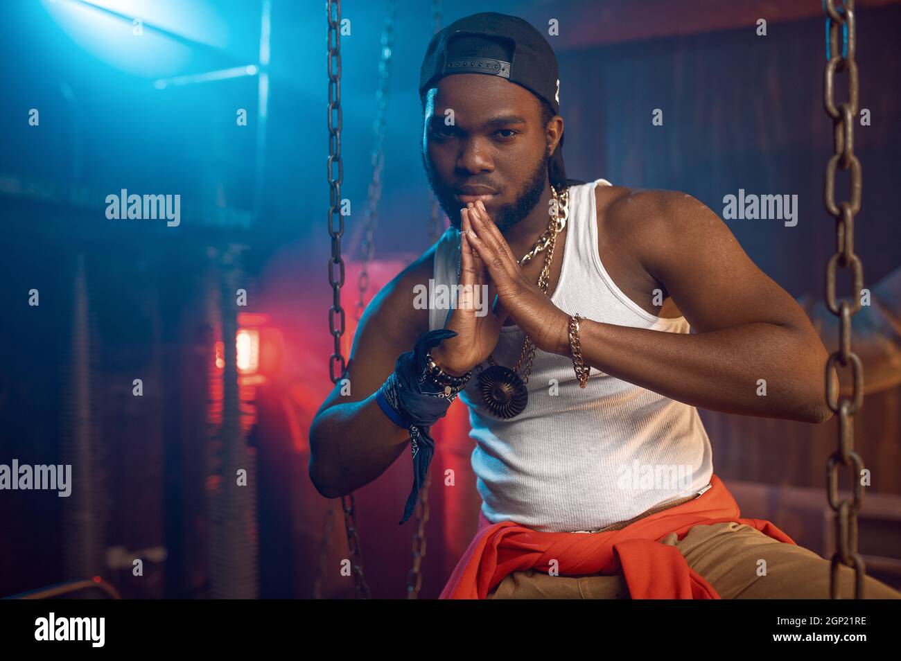 Stylish rapper poses near the chains in studio with cool underground ...