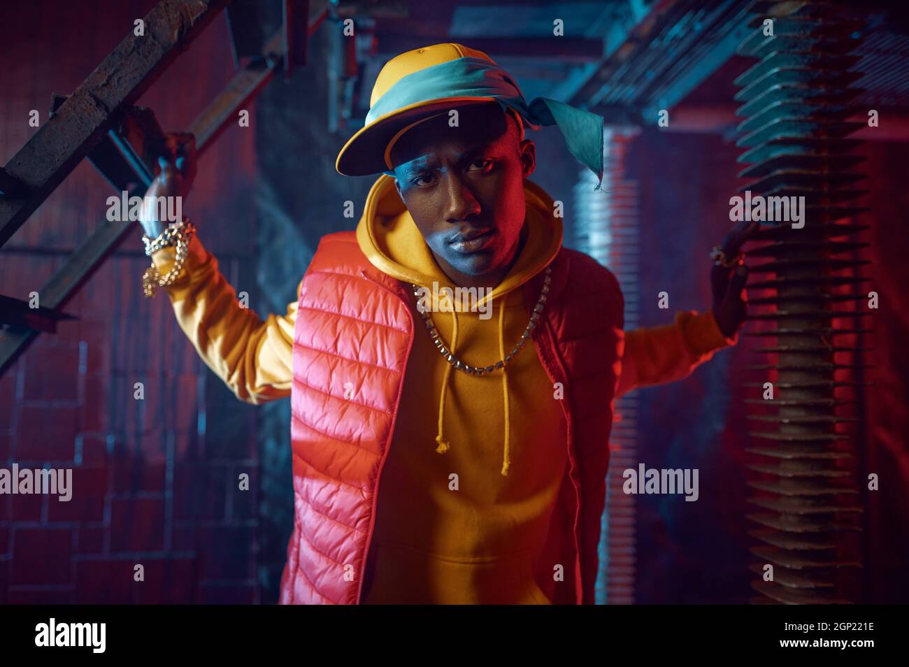 Stylish rapper in yellow hoodie posing in grunge studio with cool ...