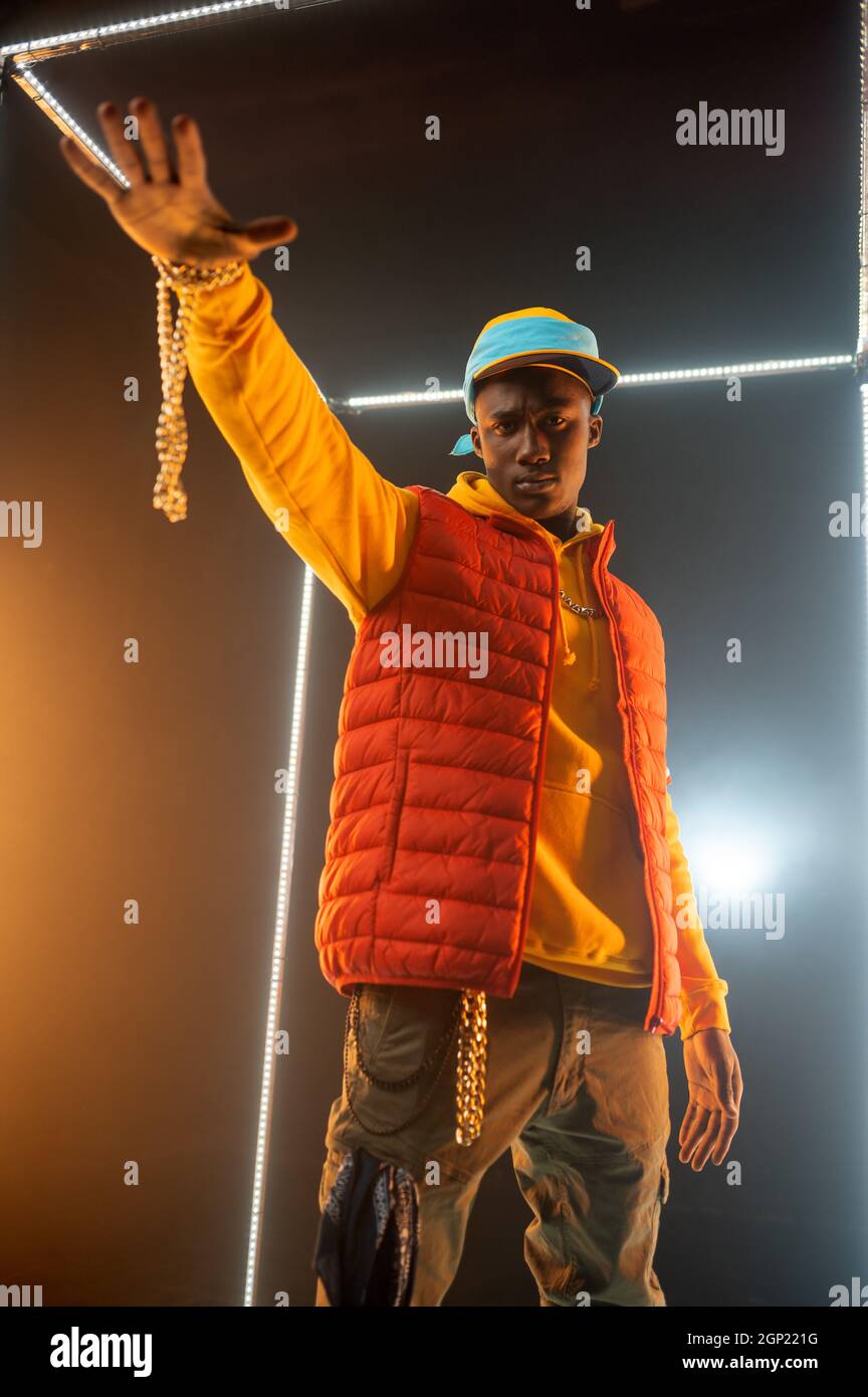 Stylish rapper on the stage with illuminated cube. Hip-hop performer ...