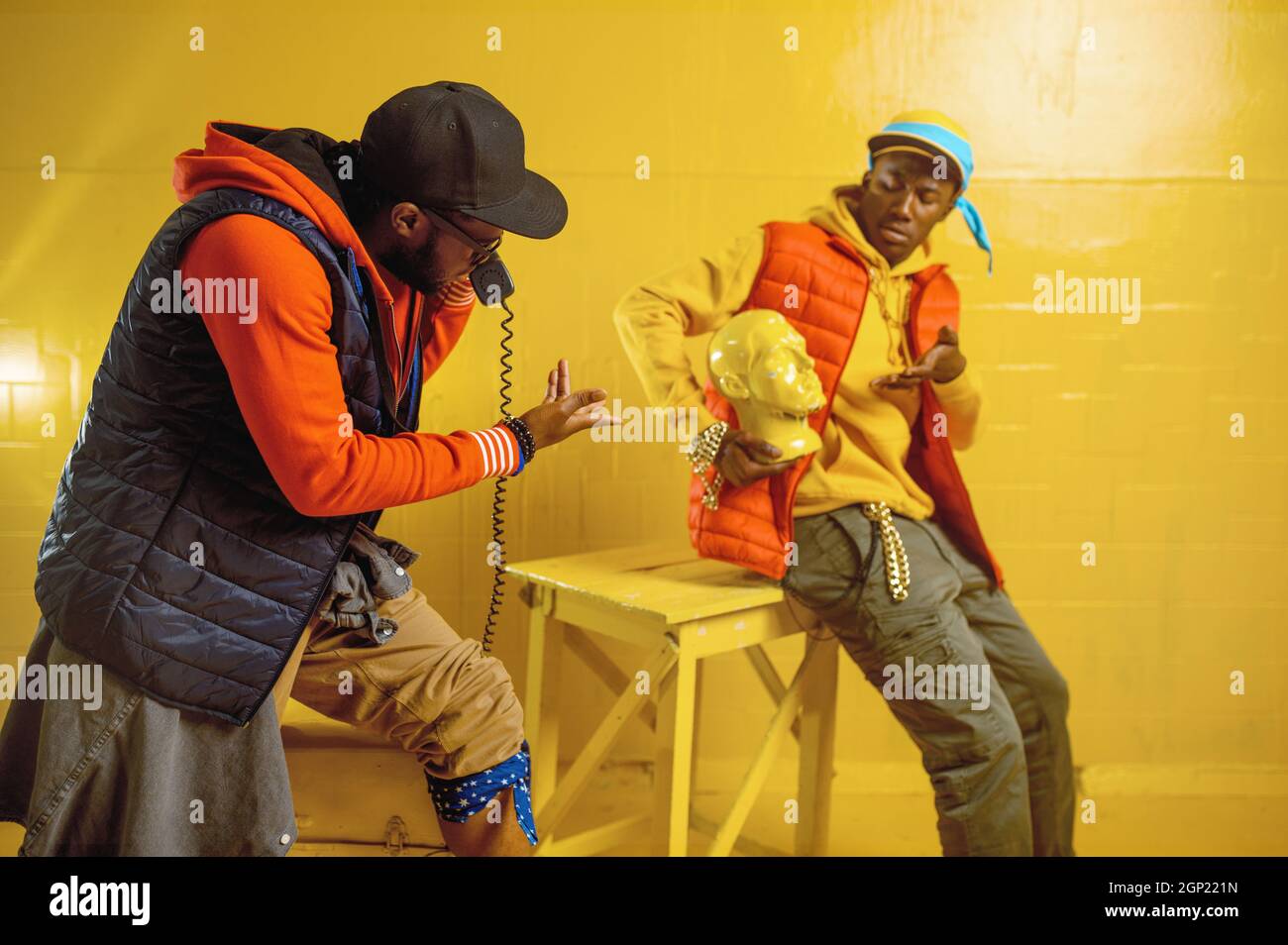Two stylish rappers poses in cool studio, yellow background. Hip-hop ...