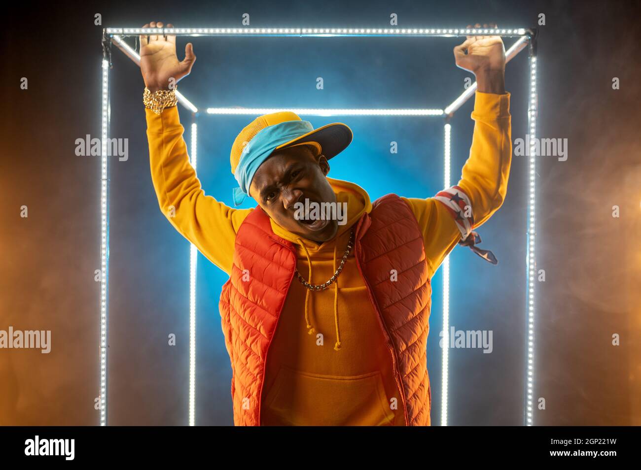 Young stylish rapper poses in illuminated cube. Hip-hop performer, rap ...