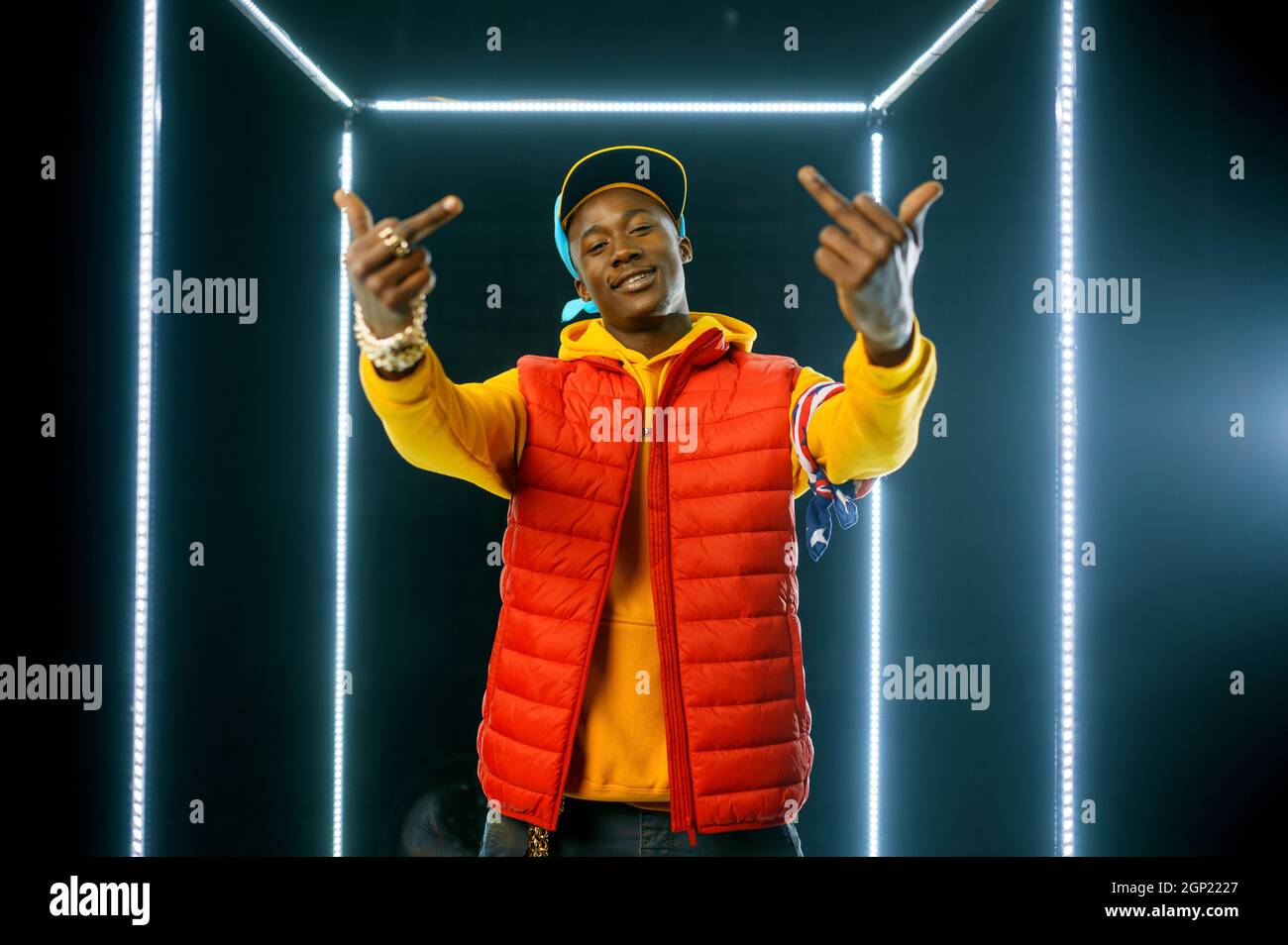 Smiling rapper on the stage with illuminated cube. Hip-hop performer ...