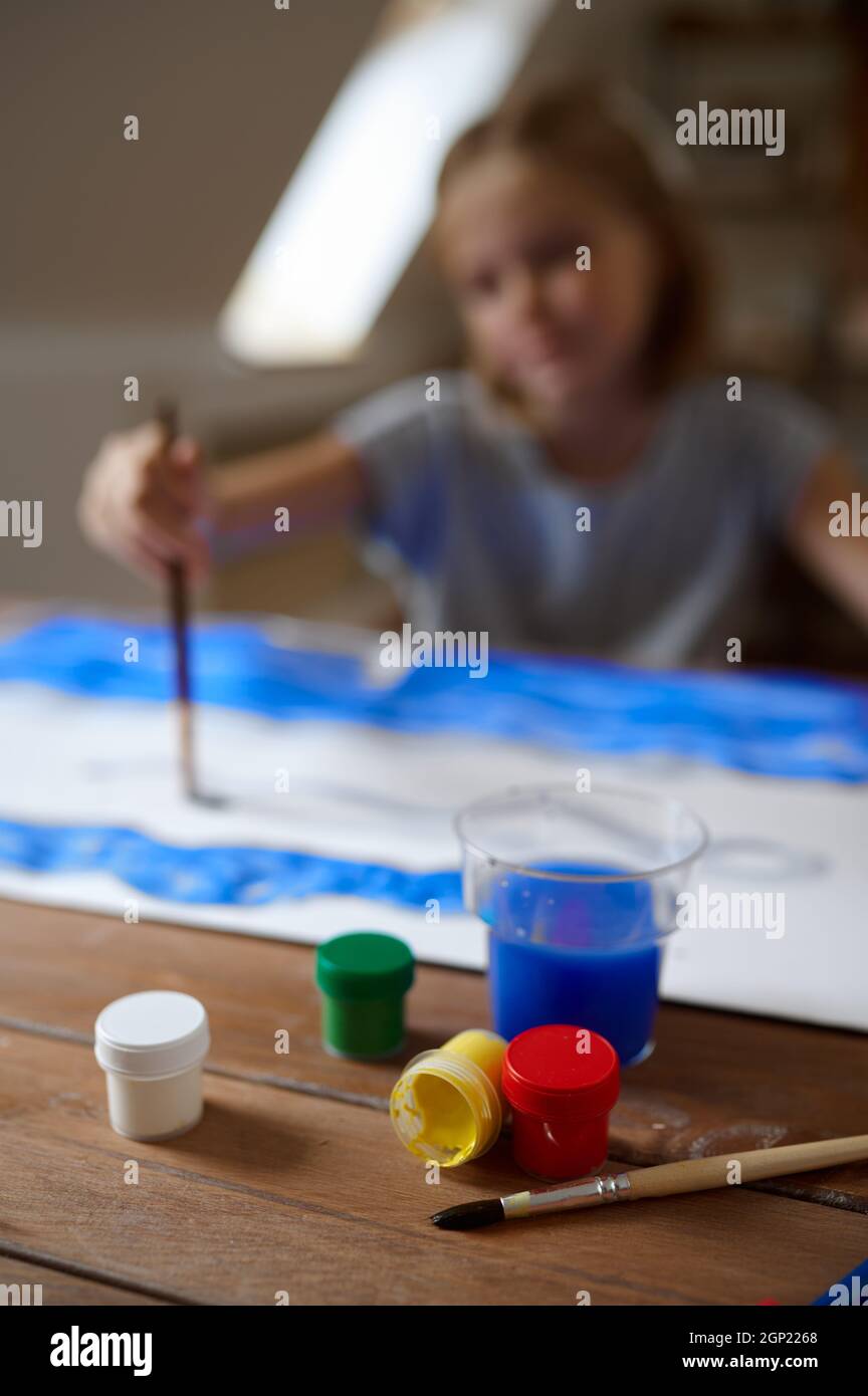 Female child drawing with brush and paints Stock Photo - Alamy