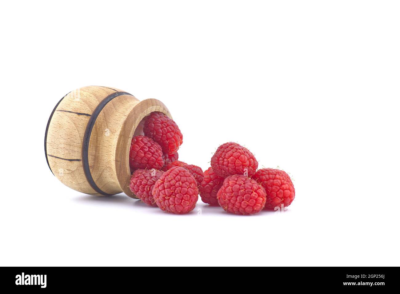 Fresh ripe raspberry spilled from a wooden pot isolated on white ...