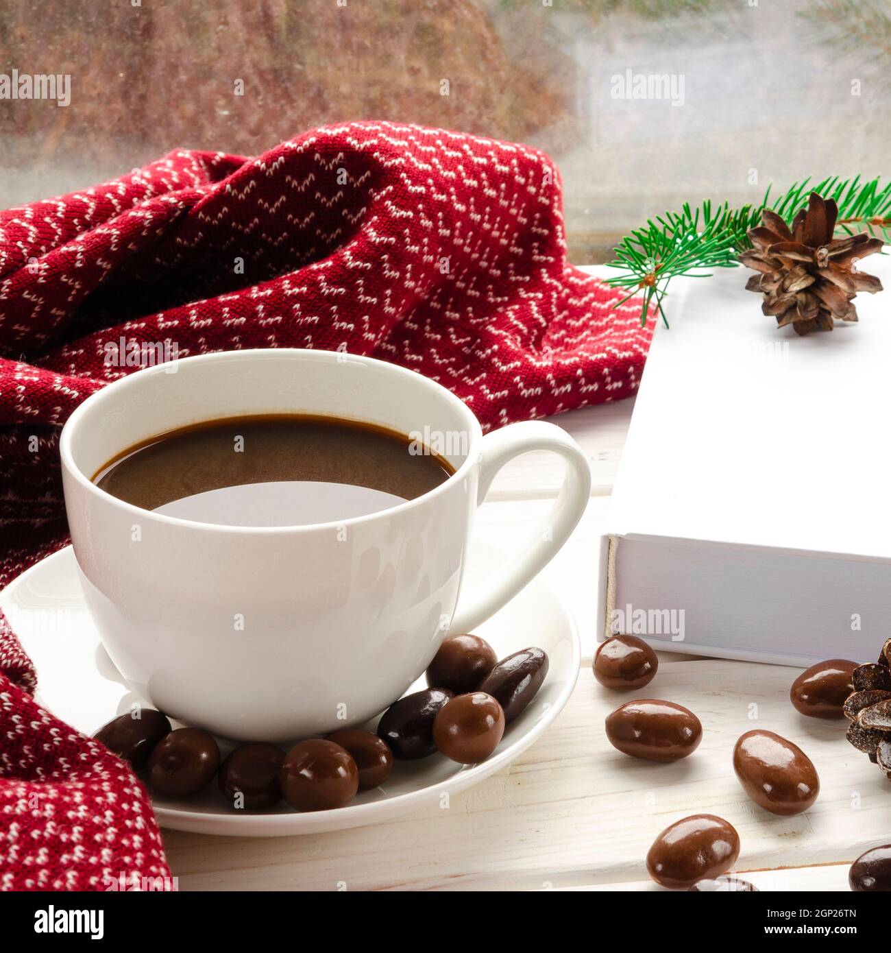 Winter background - cup with candy cane, woolen scarf on windowsill and ...