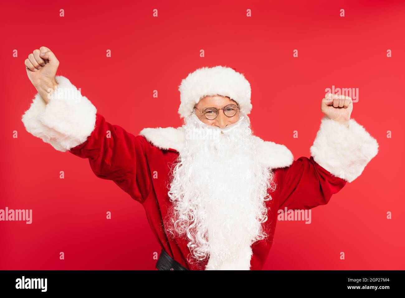 Santa claus in eyeglasses showing yes gesture isolated on red Stock ...