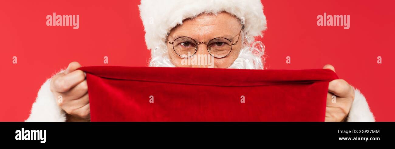 Santa claus covering face with sack isolated on red, banner Stock Photo ...