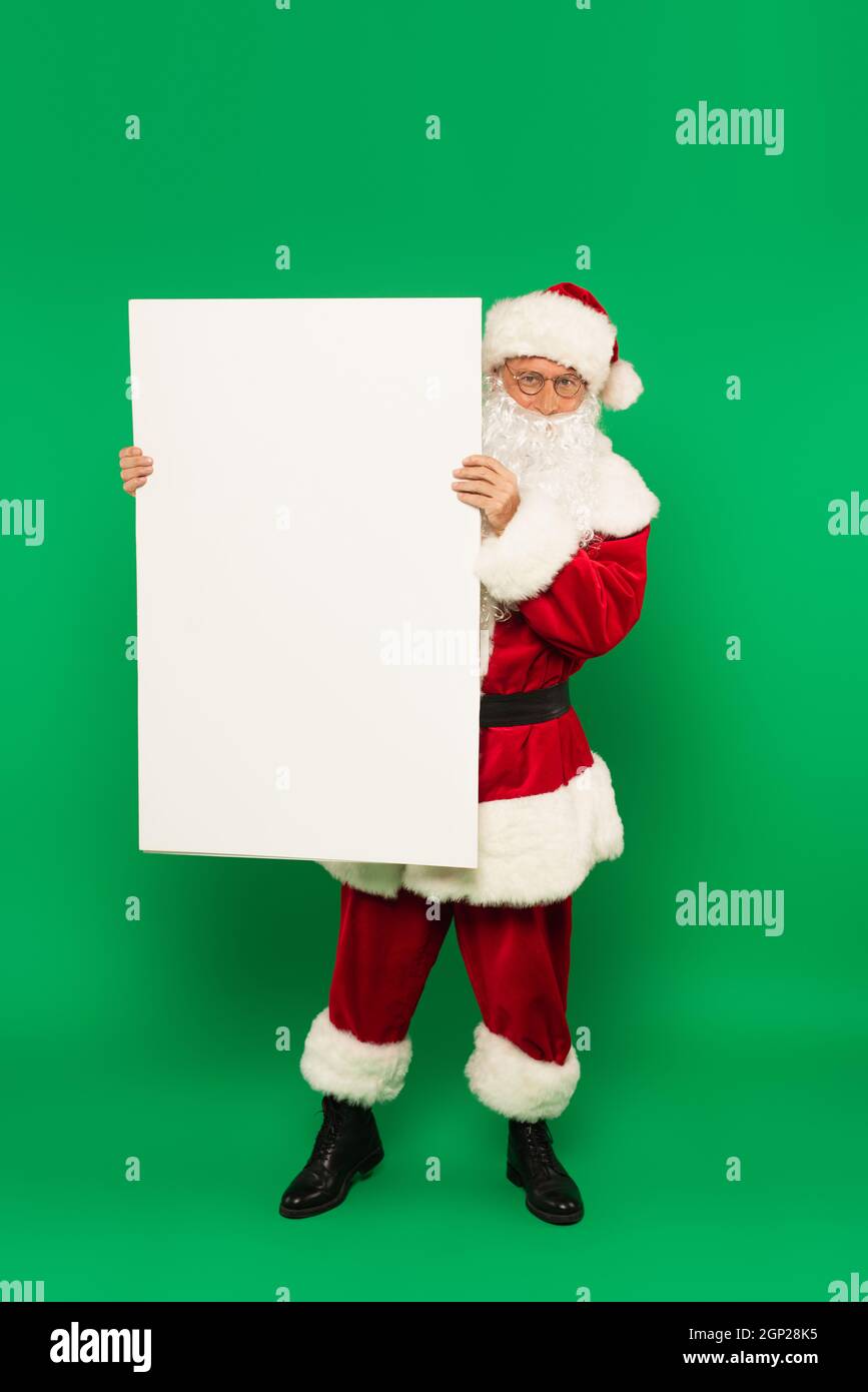 Santa claus holding placard with copy space on green background Stock ...