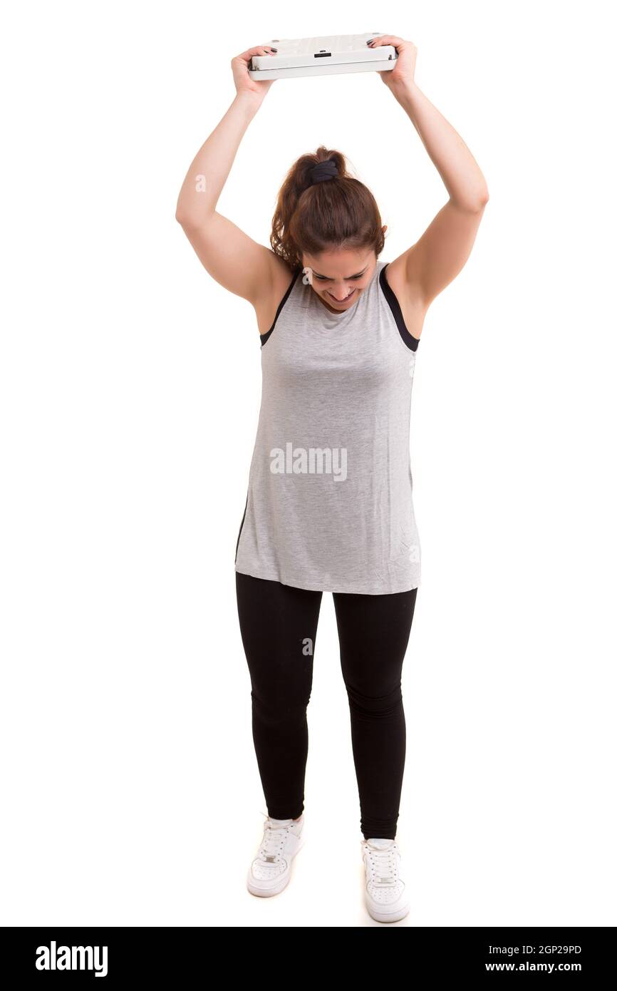 Diet concept - Mad woman destroying her scale Stock Photo - Alamy