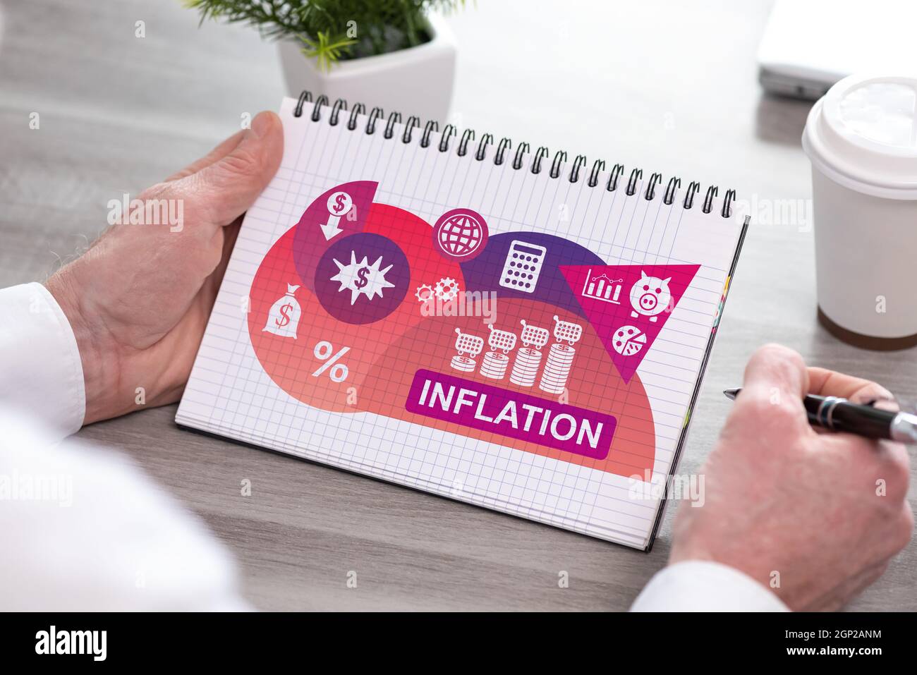 Hand holding a notepad with inflation concept Stock Photo - Alamy