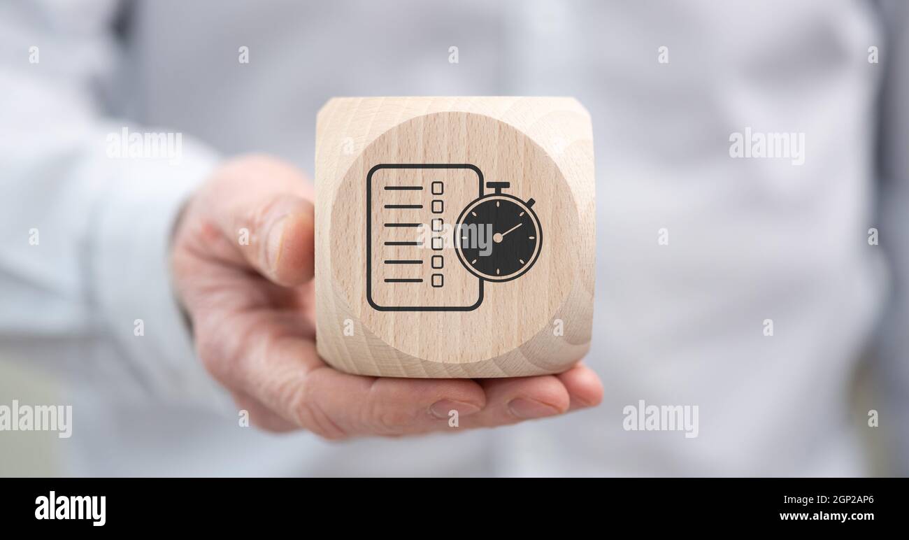 Hand holding a wooden cube with symbol of time management concept Stock ...