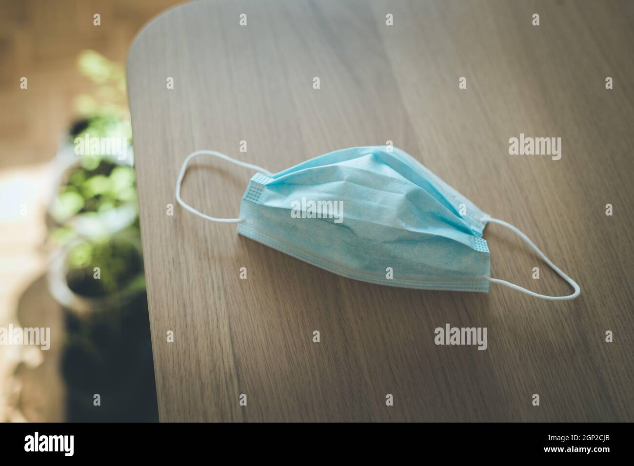 Face mask or surgical mask is lying on a wooden desk, daily routine ...
