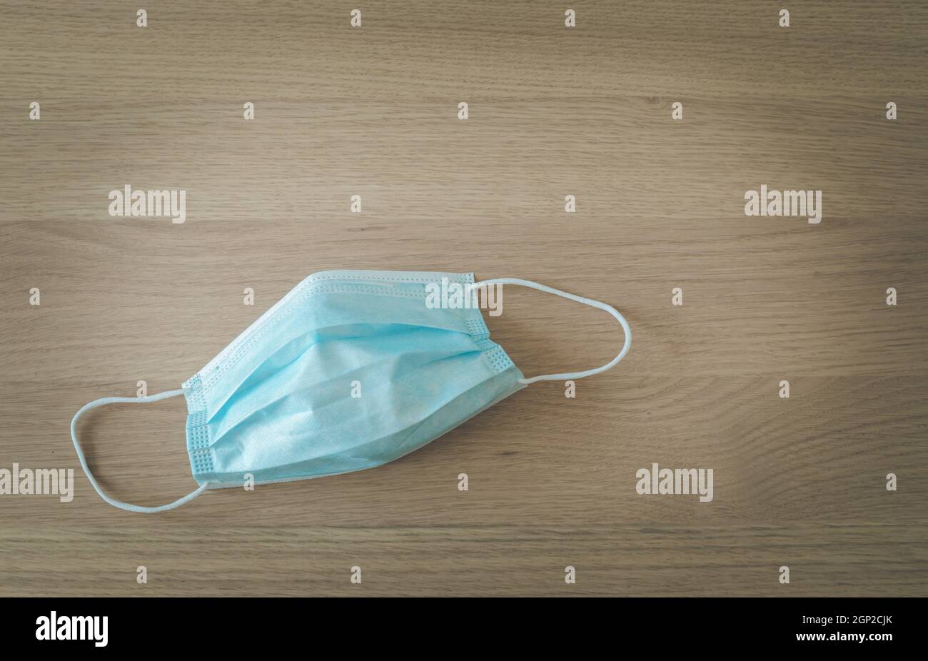 Face mask or surgical mask is lying on a wooden desk, daily routine ...