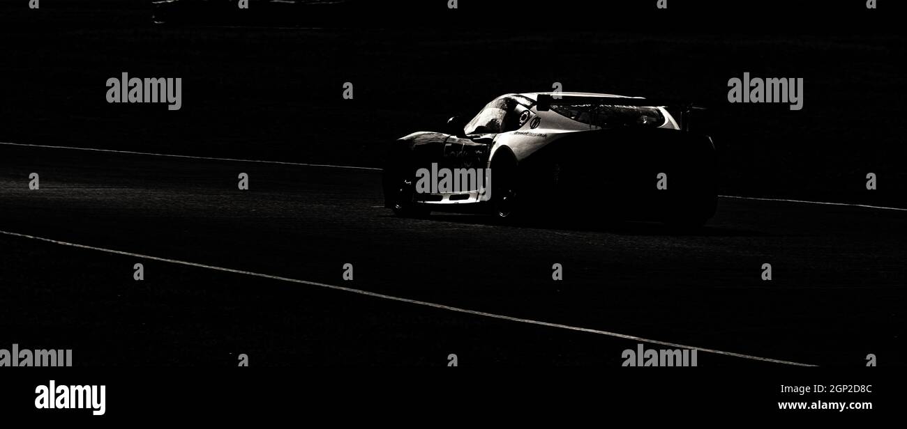 A sports car racing on track into the sun in black and white Stock ...