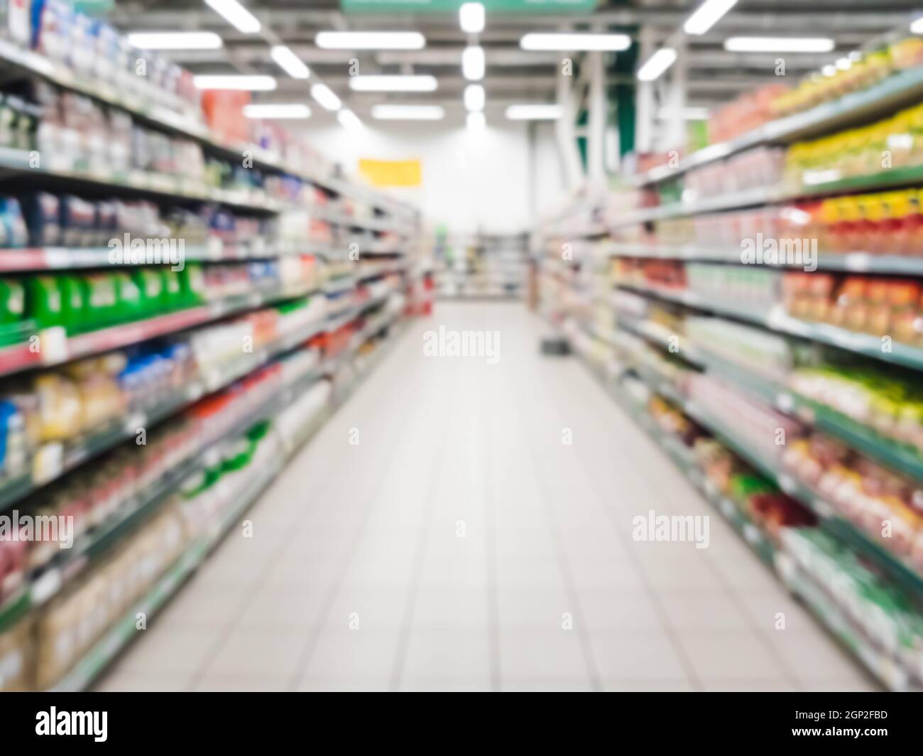 Blurred supermarket aisle with colorful shelves of merchandise ...