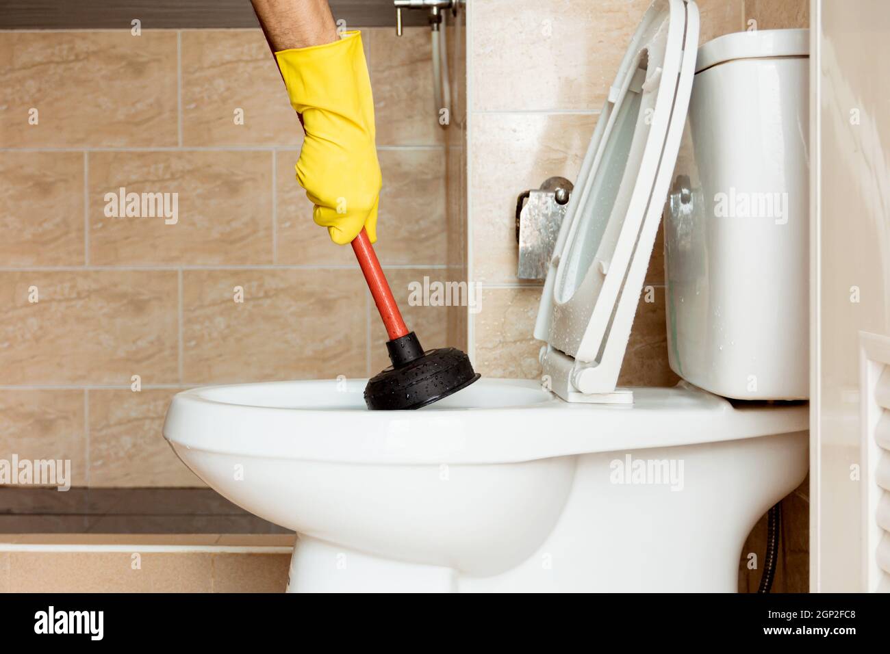 Human hand wearing yellow rubber gloves is using a device to fix a ...