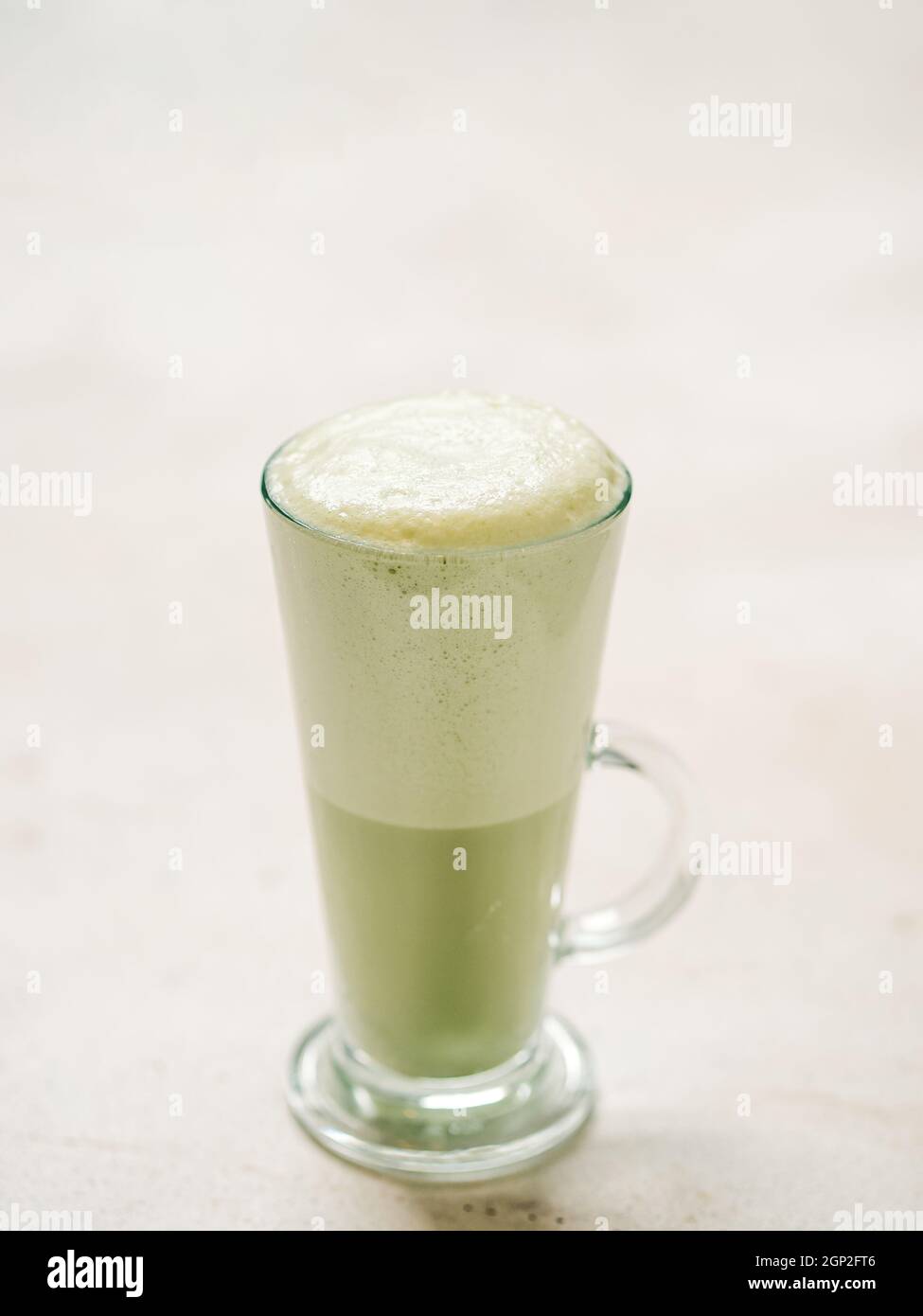 Matcha green tea latte in glass. Matcha latte on light background. Copy ...