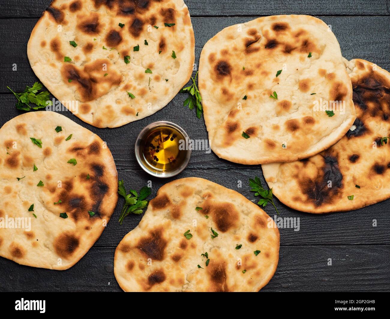 Fresh naan bread on dark wooden background with copy space. Several ...