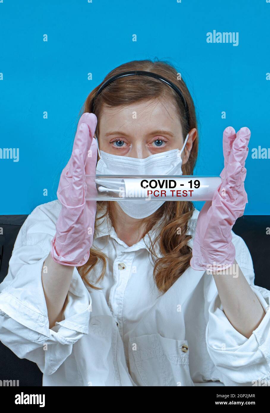 Young nurse wearing protective face mask and gloves holding swabs of ...