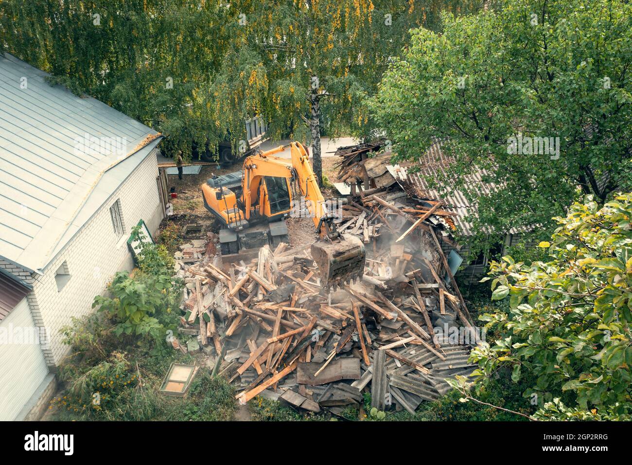 Process of demolition of old building dismantling. Excavator breaking ...