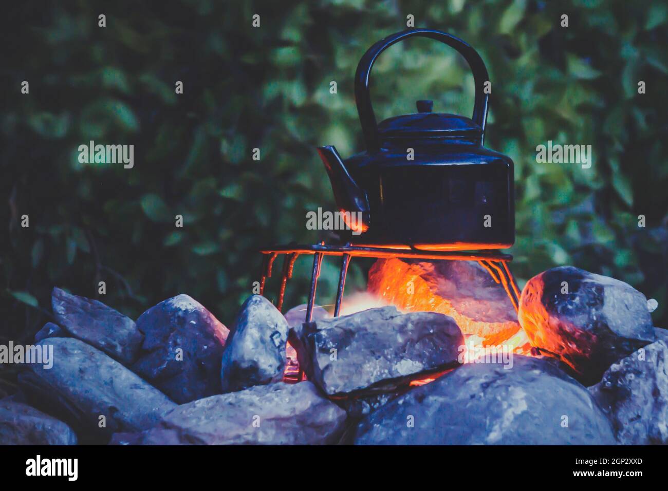 Adventure cooking during camping: metal kettle boiling on a campfire ...
