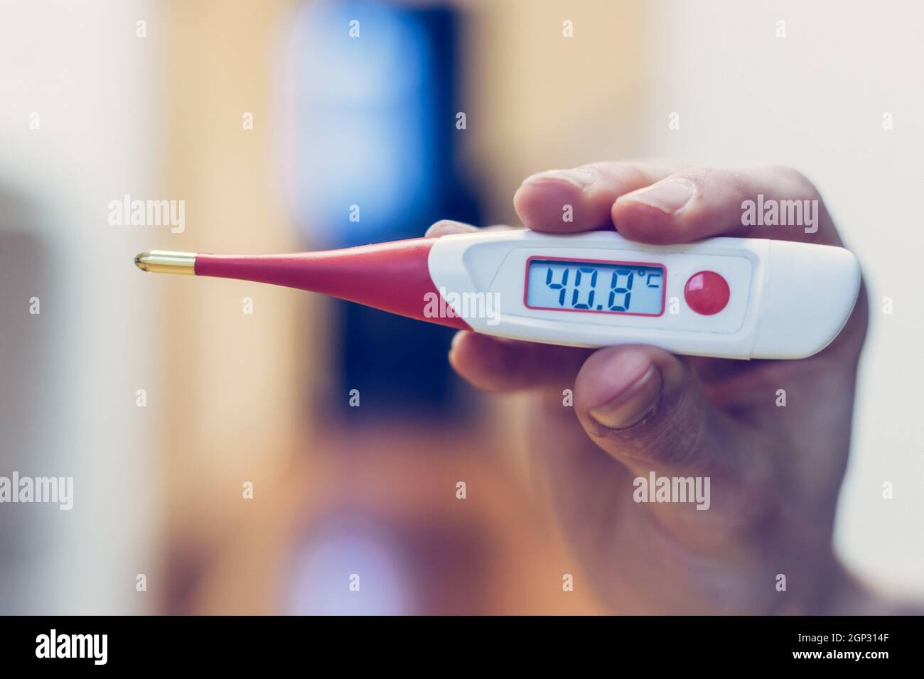 Man is holding a red fever thermometer in his hand Stock Photo - Alamy