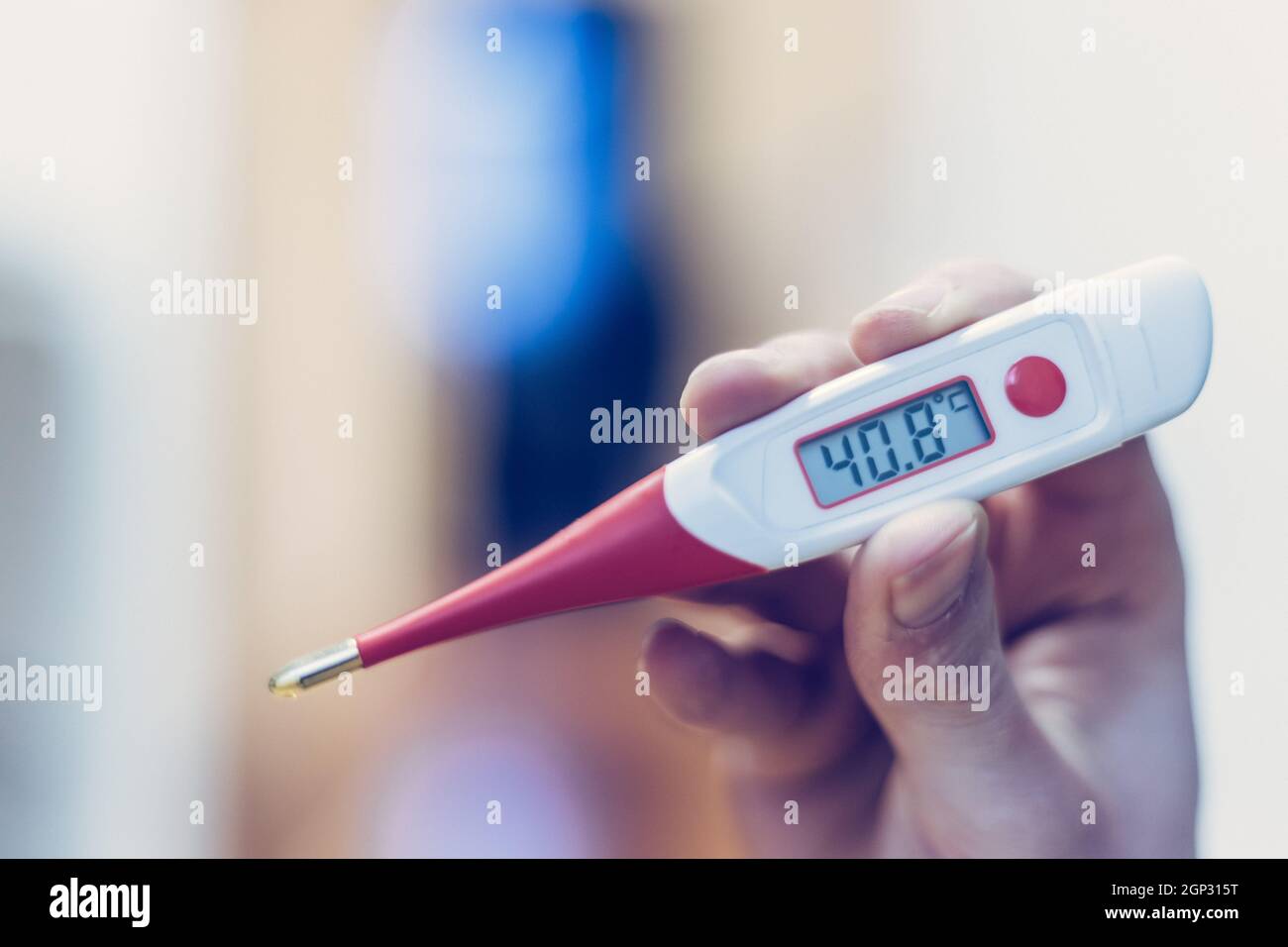 Man is holding a red fever thermometer in his hand Stock Photo - Alamy