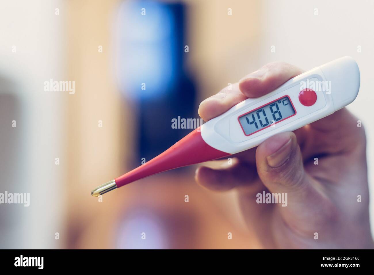 Man is holding a red fever thermometer in his hand Stock Photo - Alamy