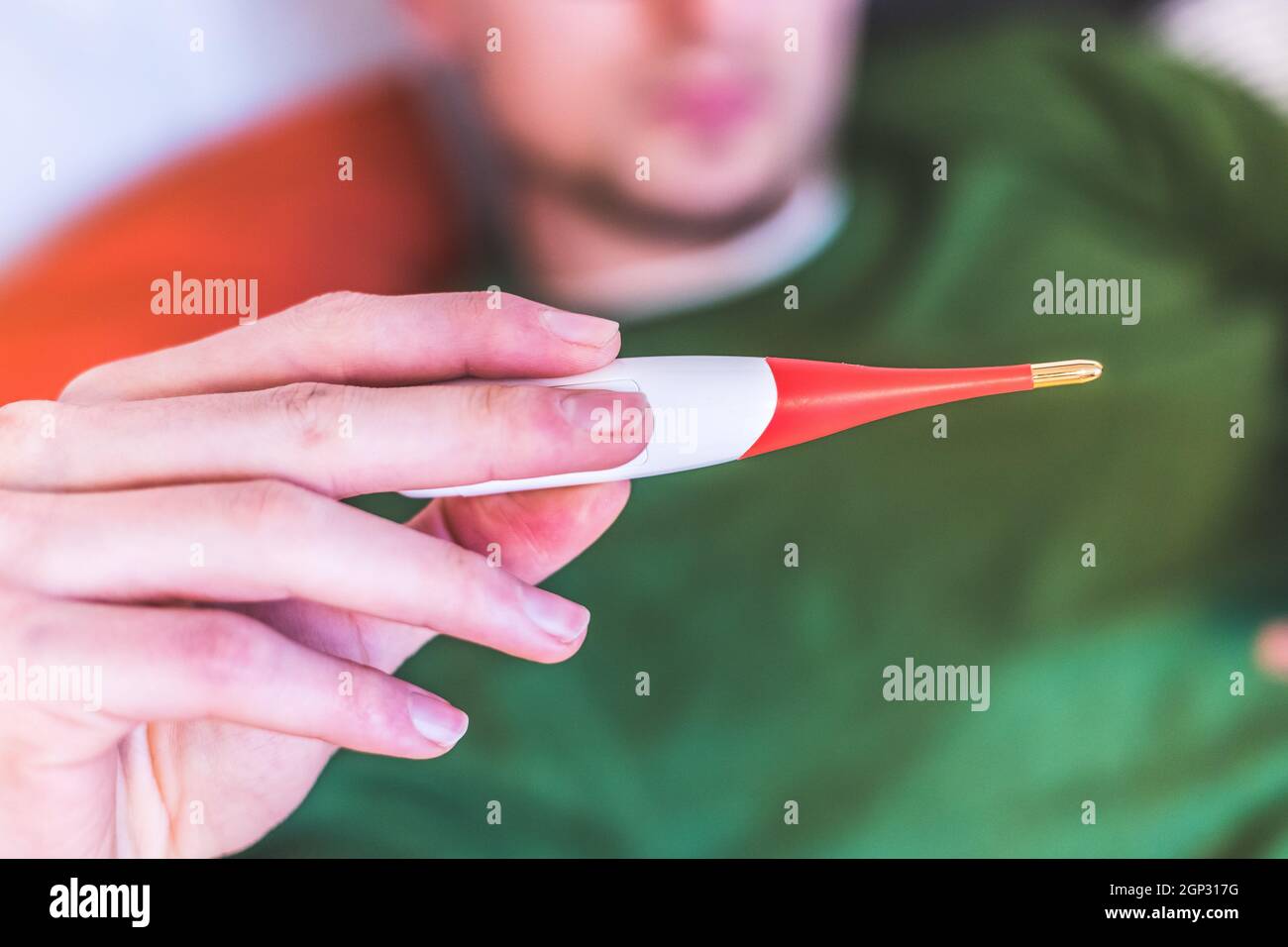 Man is holding a red fever thermometer in his hand Stock Photo - Alamy