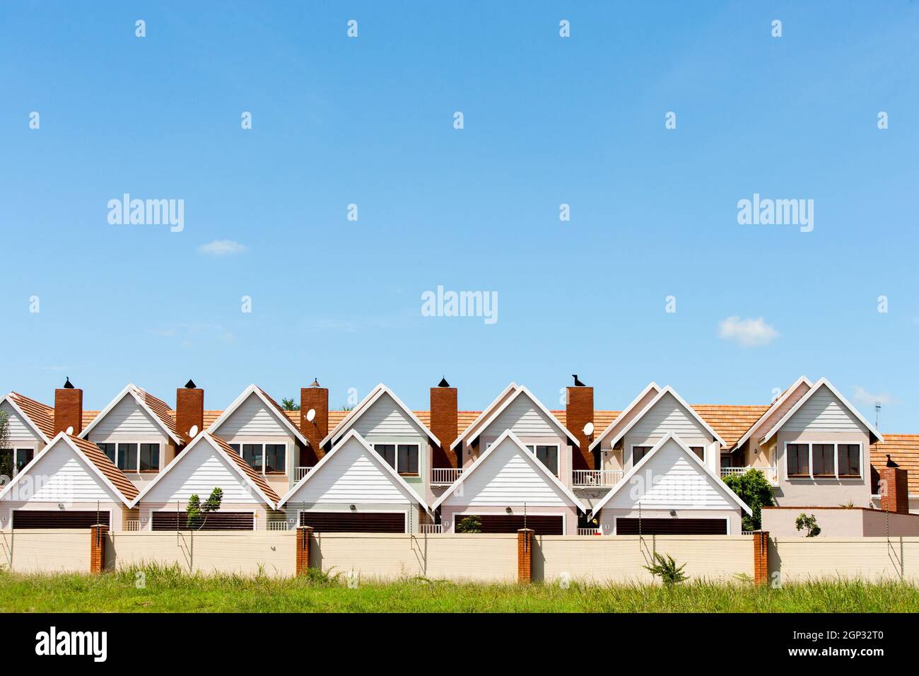 Residential fenced house complex against blue sky Stock Photo - Alamy