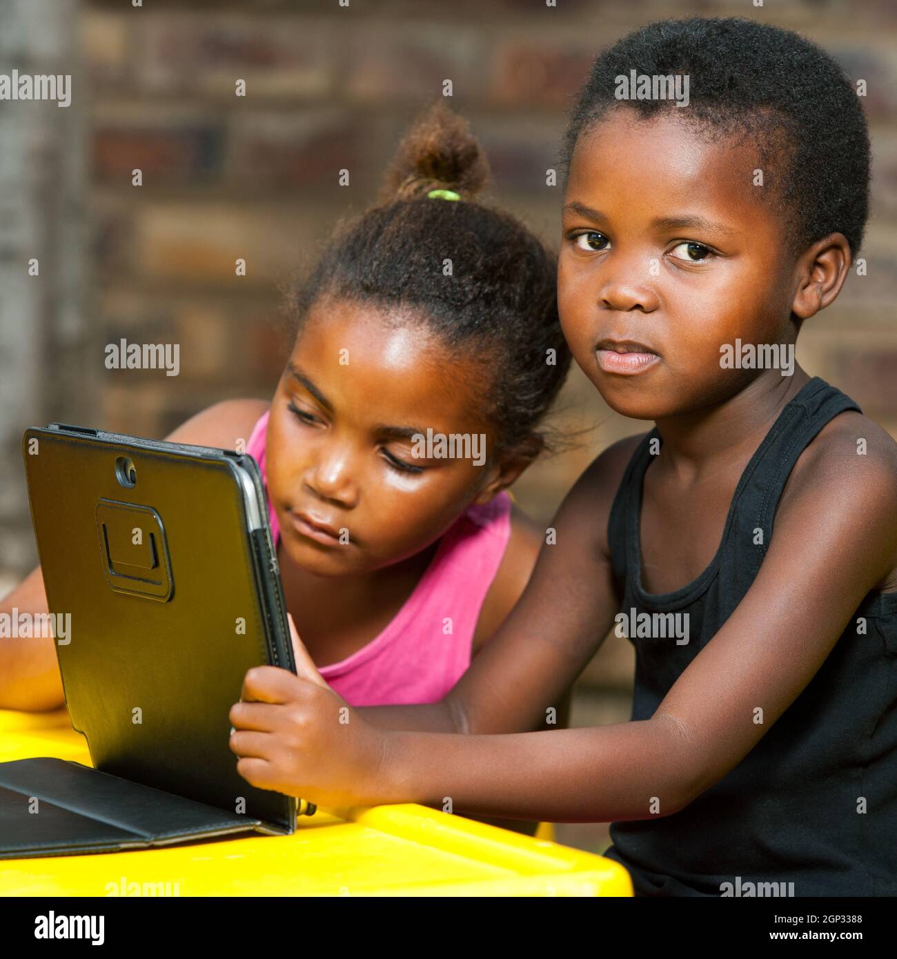 Close up of two african kids doing homework on tablet outdoors Stock ...