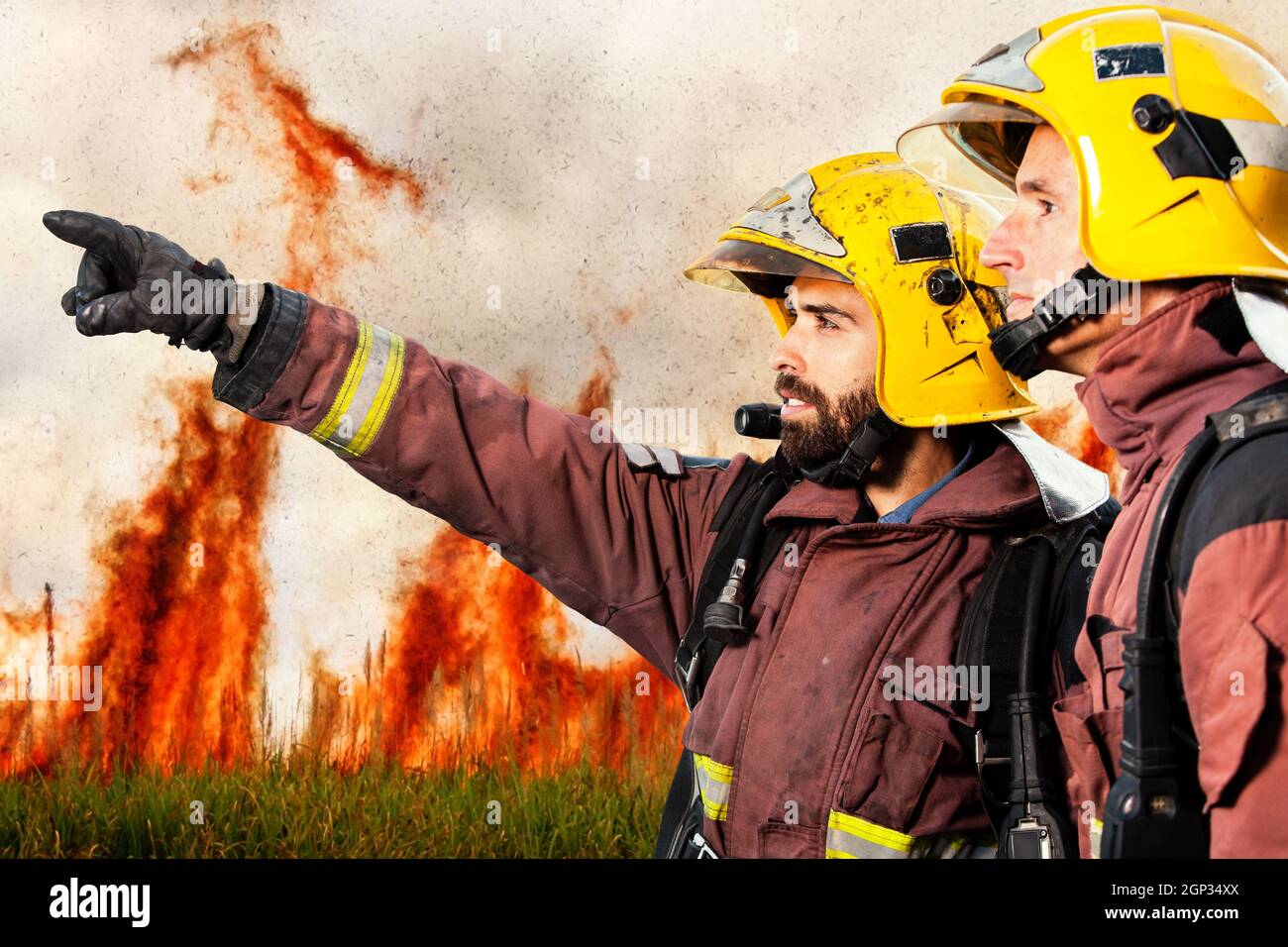 Firemen looking and pointing at danger situation with high flames in ...