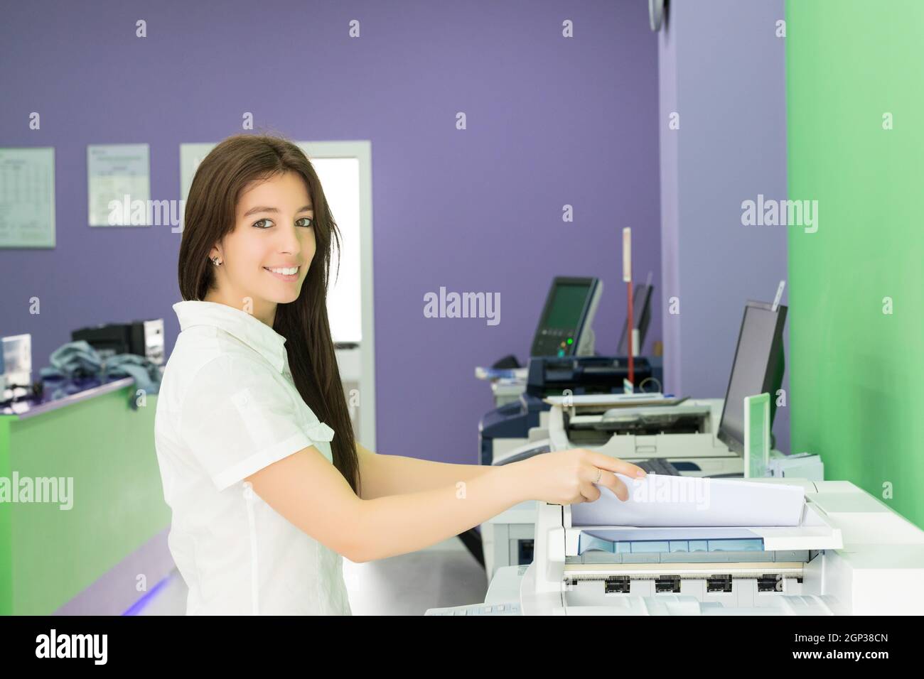 A young student at a copy center taking some copies for her final exams ...