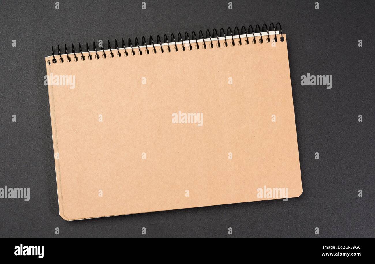 closed notepad with brown sheets on black background, close up Stock Photo - Alamy