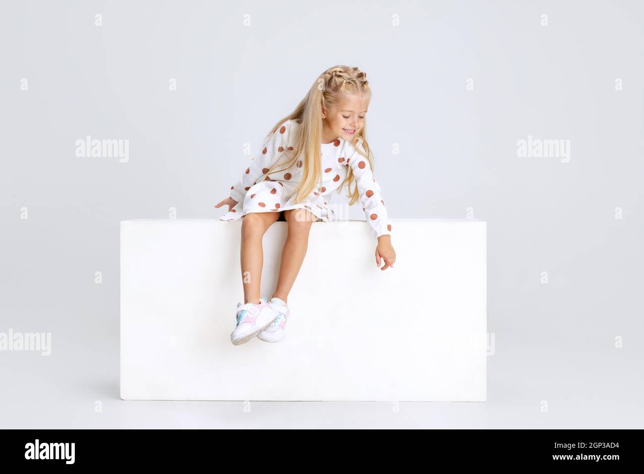 Portrait of little preschool girl pointing away isolated over white ...