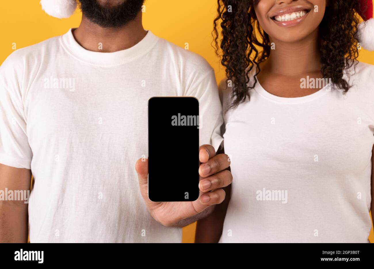 Young african american couple showing smartphone with blank screen ...