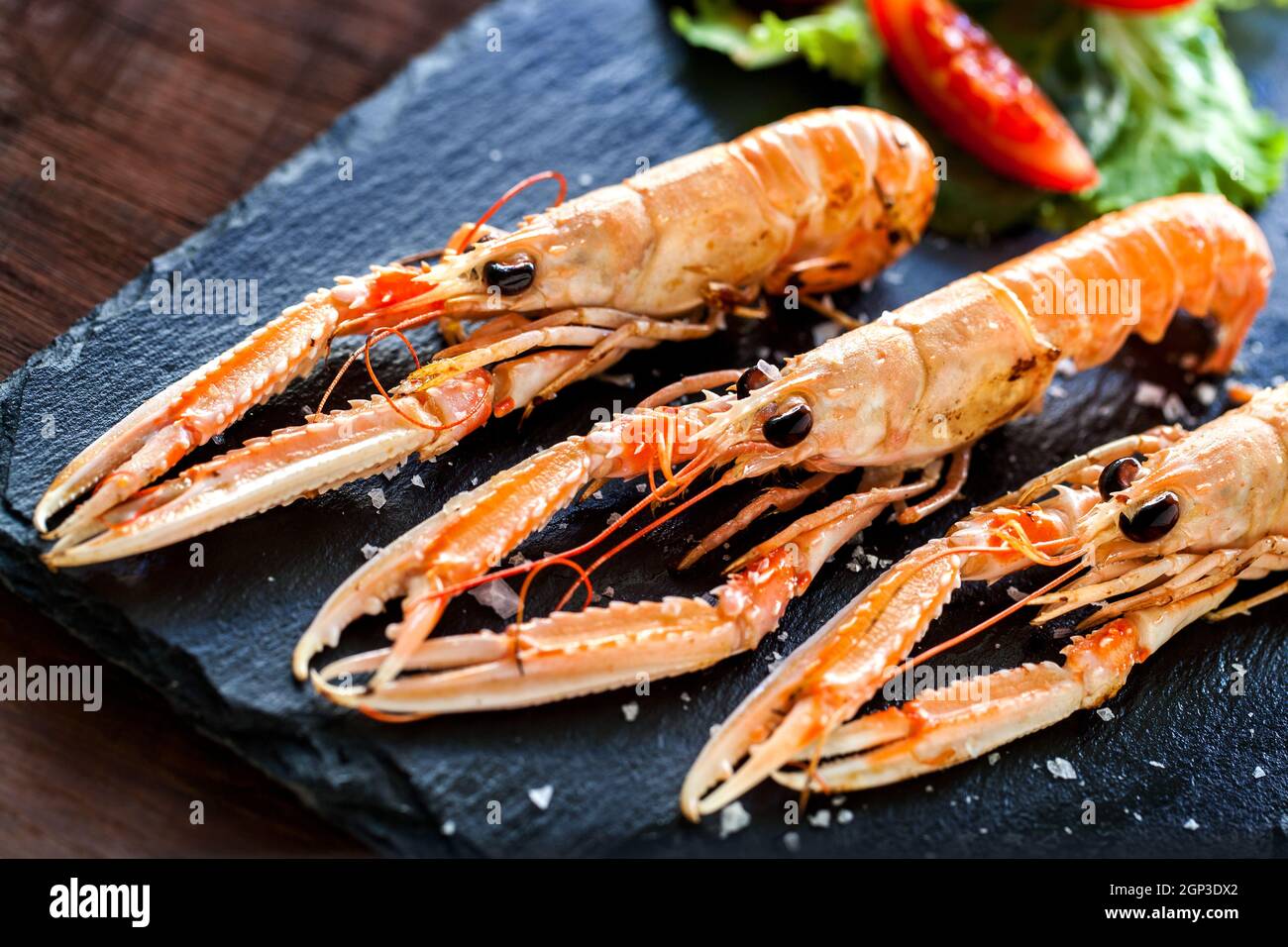 Macro close up of fresh grilled crawfish platter with green salad ...